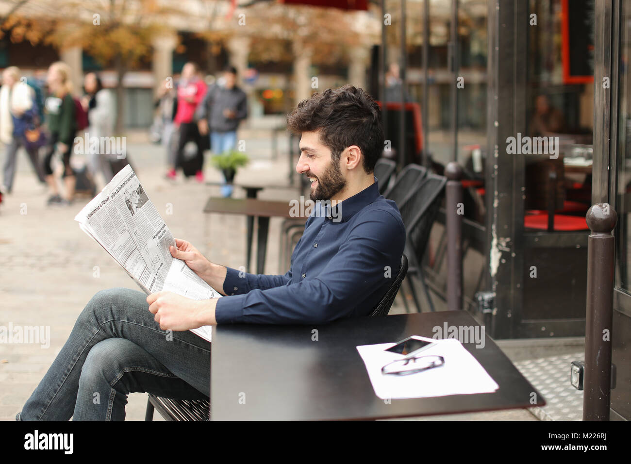 Journalist with close up face reading newspaper article at cafe Stock ...