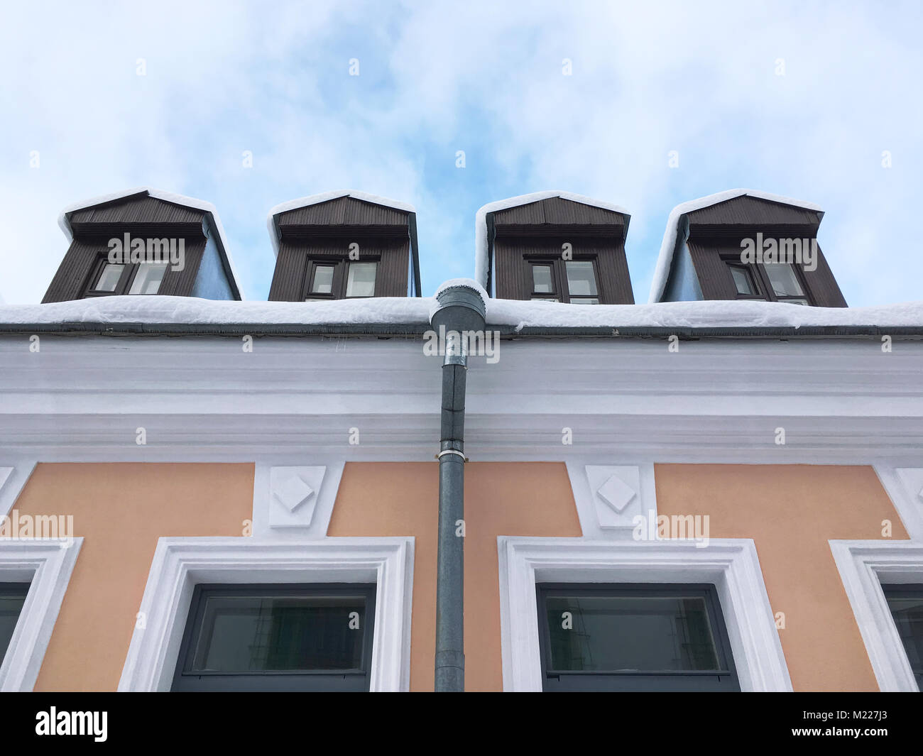 roof of city building covered with snow against blue sky background ...