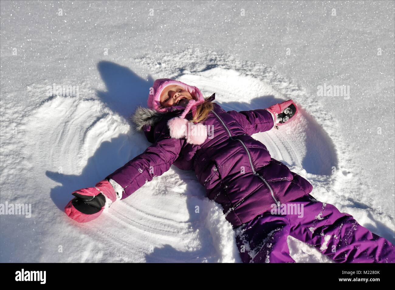 Girl playing in the snow Stock Photo - Alamy