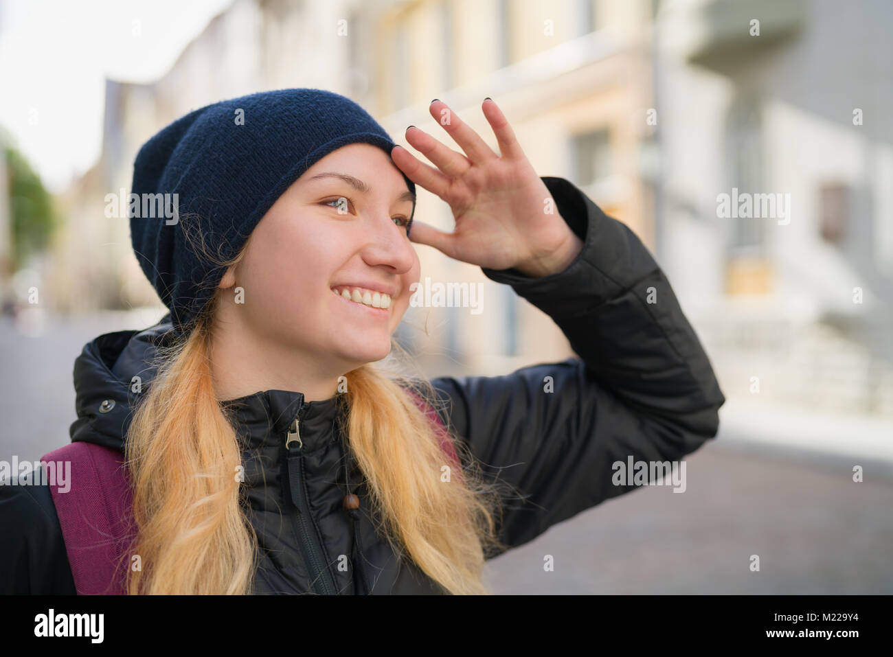 portrait of teen girl looking for something on street of old europe ...