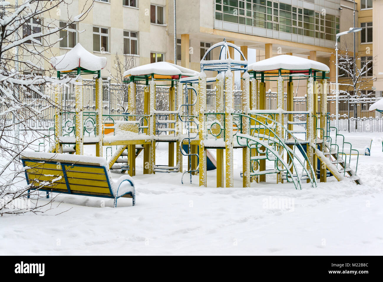 children's play complex and bench in the snow around the building Stock ...