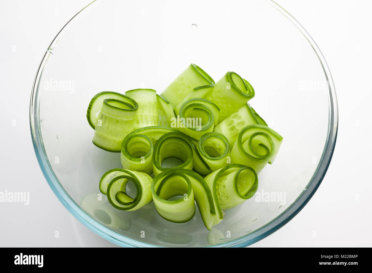 Rolled cucumber slices in glass bowl on white Stock Photo - Alamy