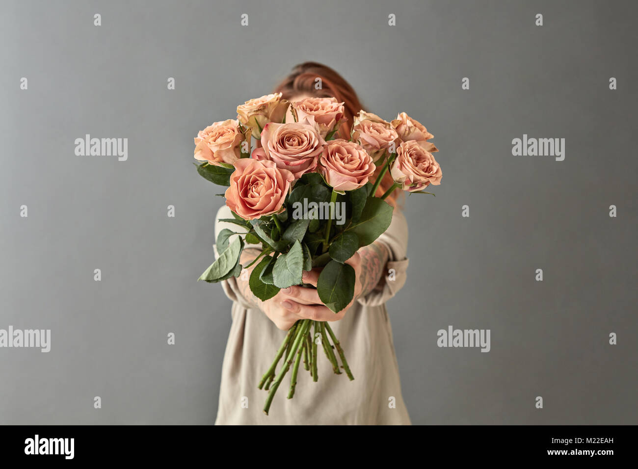 A woman gives a bouquet of beige roses Stock Photo - Alamy