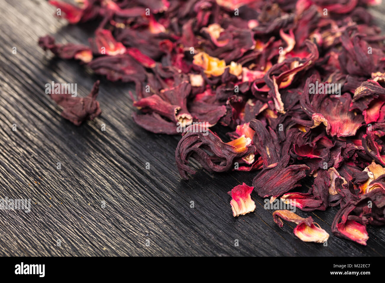 dry karkade tea on a wooden black background Stock Photo - Alamy