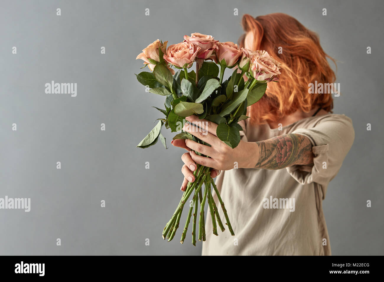 Red-haired girl gives a beige roses cappuccino Stock Photo - Alamy