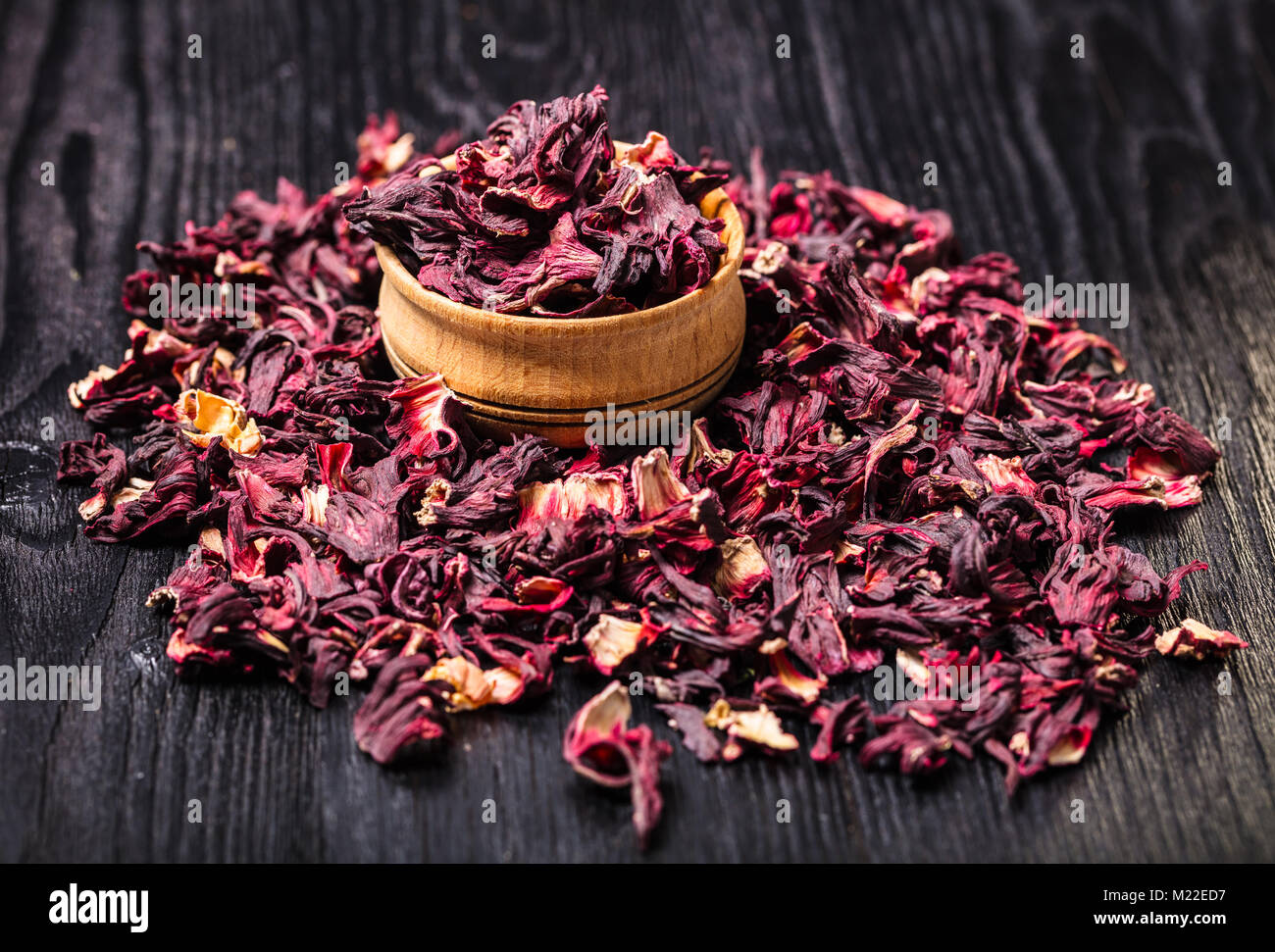 dry karkade tea on a wooden black background Stock Photo - Alamy