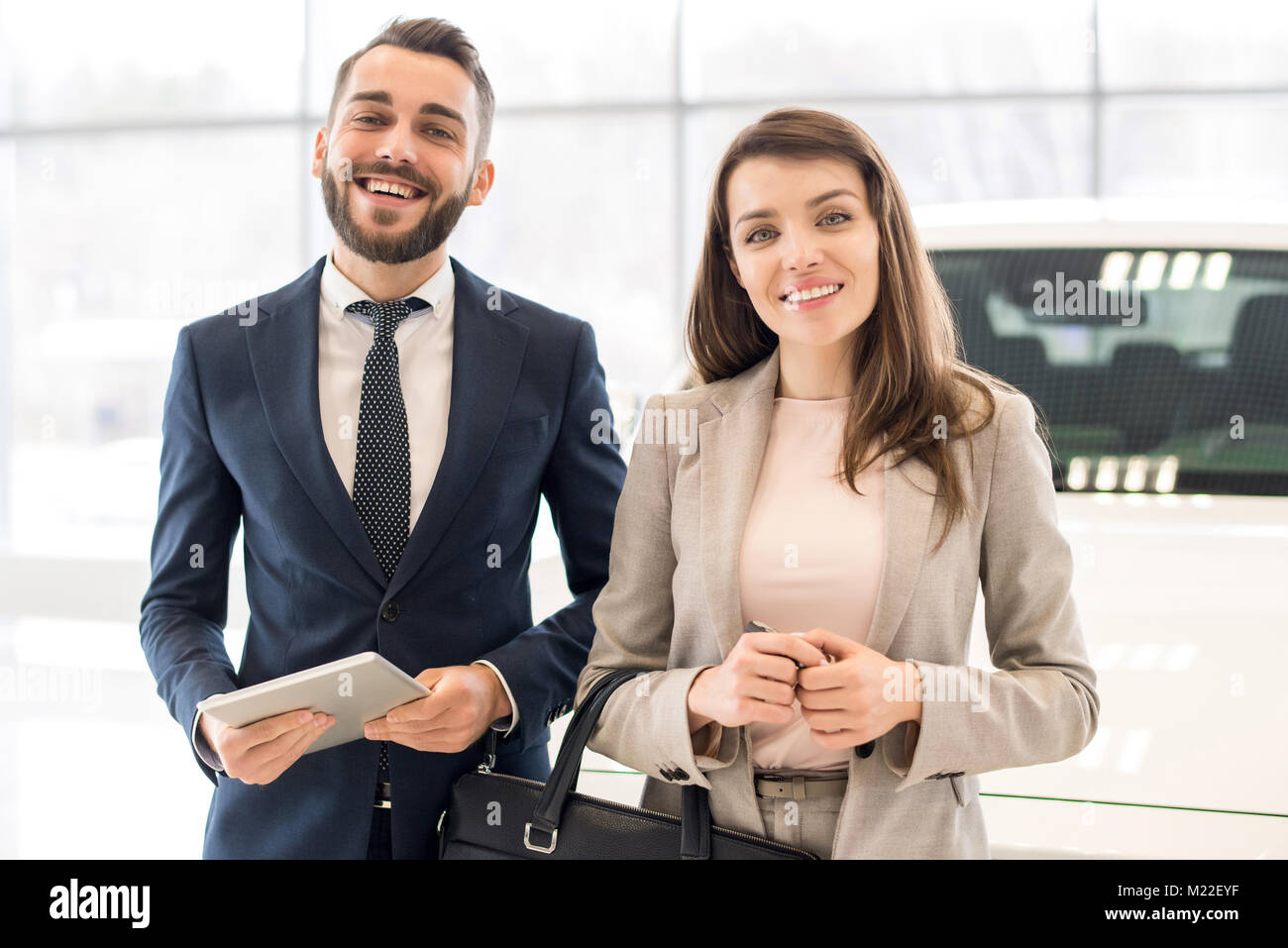 Portrait of beautiful business couple smiling cheerfully at camera ...