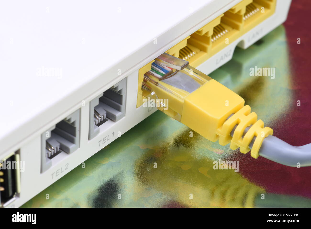 Network cable connected to internet router on metal table with ...