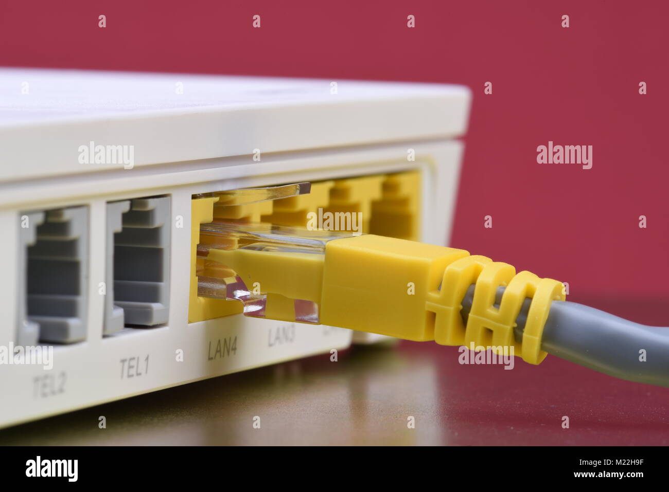 Network cable connected to internet router on metal table with ...