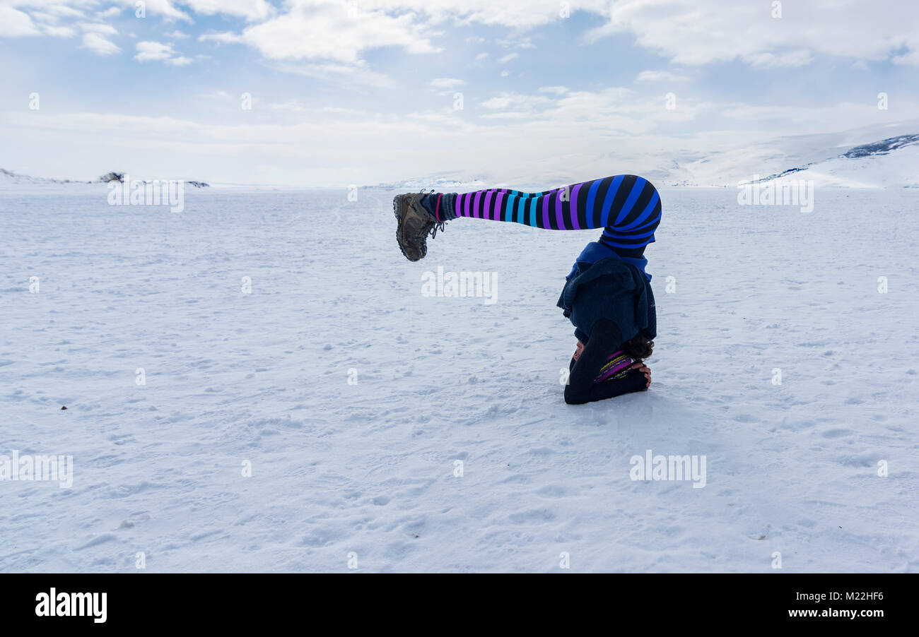 A yogi trying yoga positions on a frozen lake, Cildir lake, Kars ...