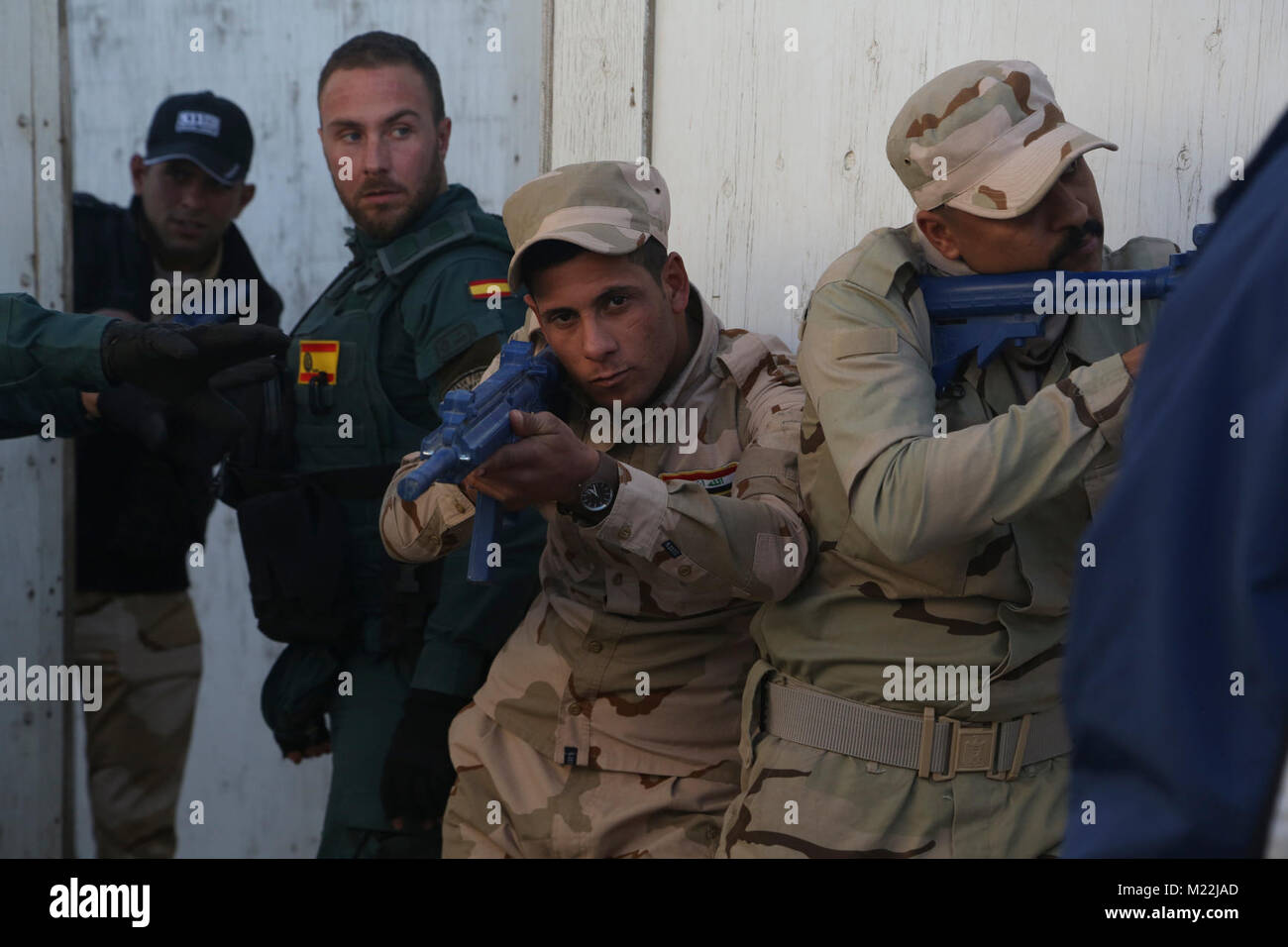 A Spanish Guardia Civil soldier stands by and watches as Iraqi soldiers ...