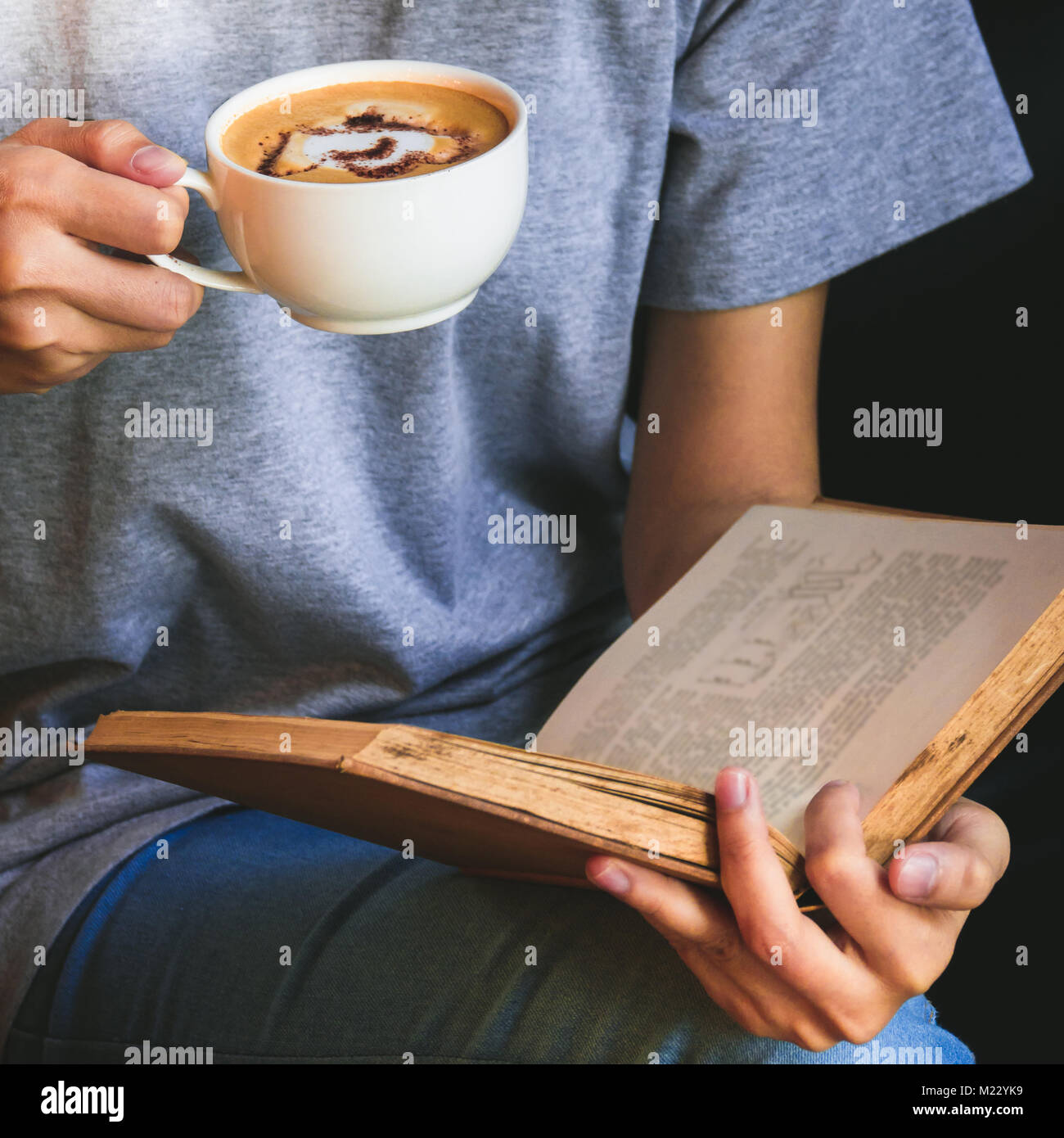 Young girl reading a book and drinking coffee Stock Photo - Alamy