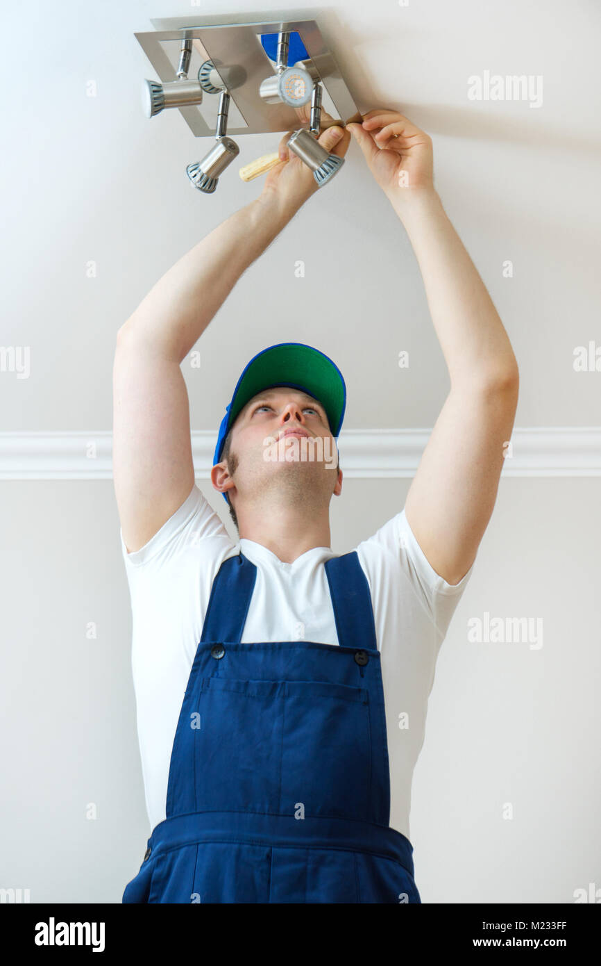 Handsome male electrician changing the light bulb Stock Photo - Alamy