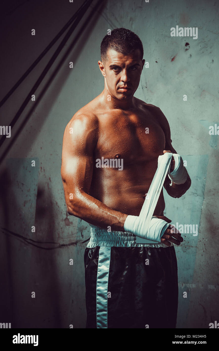 Muscular young man boxer wrapping hand with bandage. Fighter Man ...