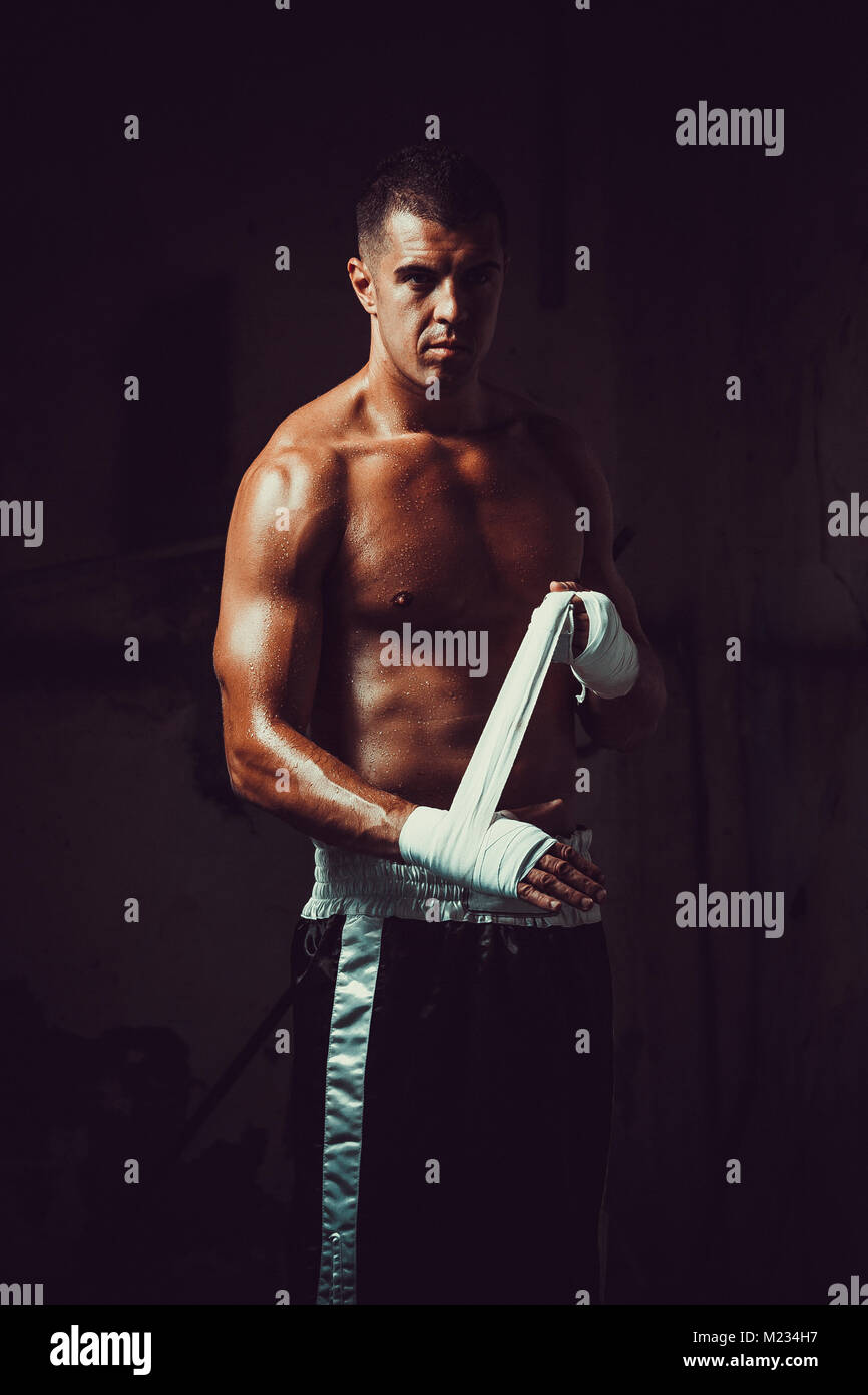 Muscular young man boxer wrapping hand with bandage. Fighter Man ...
