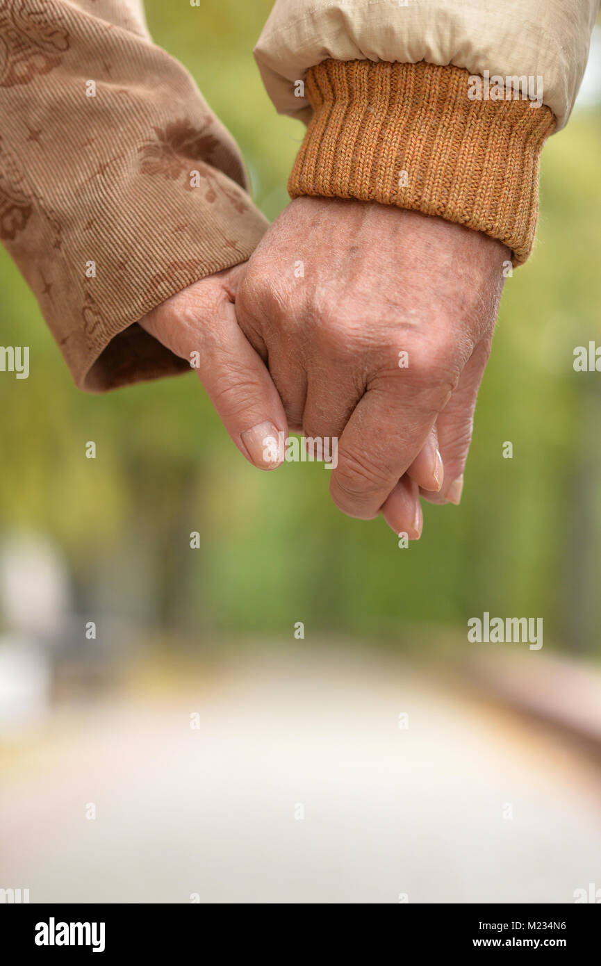 Elderly couple holding hands Stock Photo - Alamy