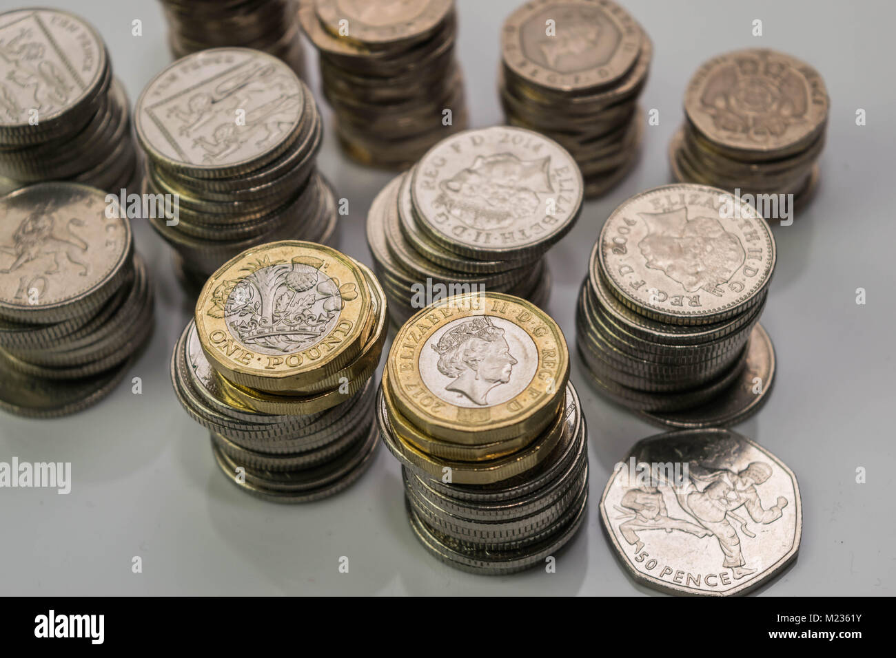 Stacks of different British coins on a white background Stock Photo - Alamy