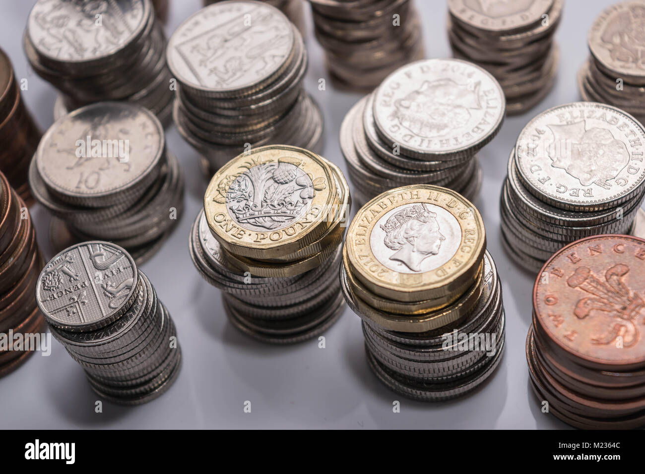 Stacks of different British coins on a white background Stock Photo - Alamy