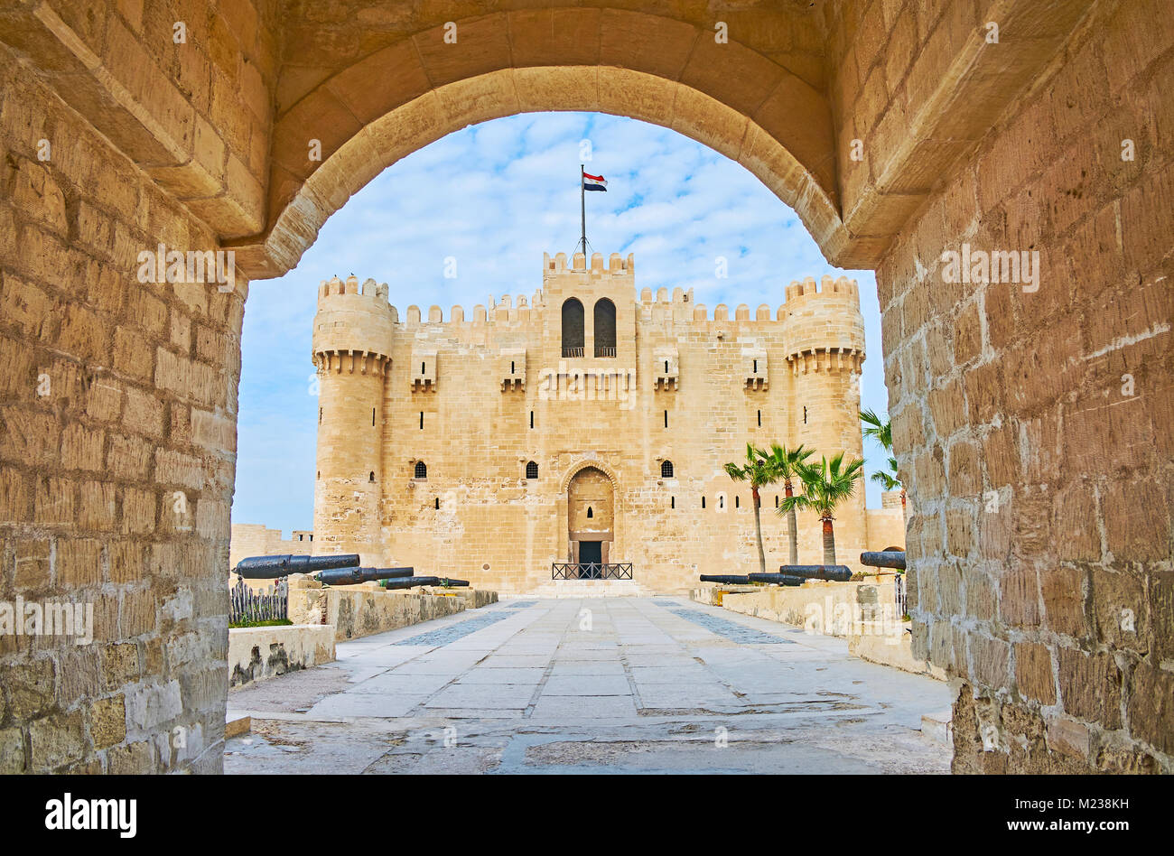 The view on the Qaitbay Fort through its entrance stone gate, the alley ...