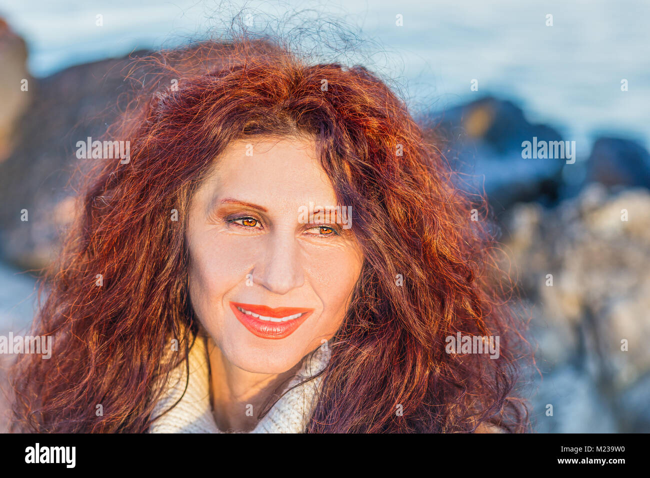 menopausal woman with red copper hair and sun-lit face smiling Stock ...