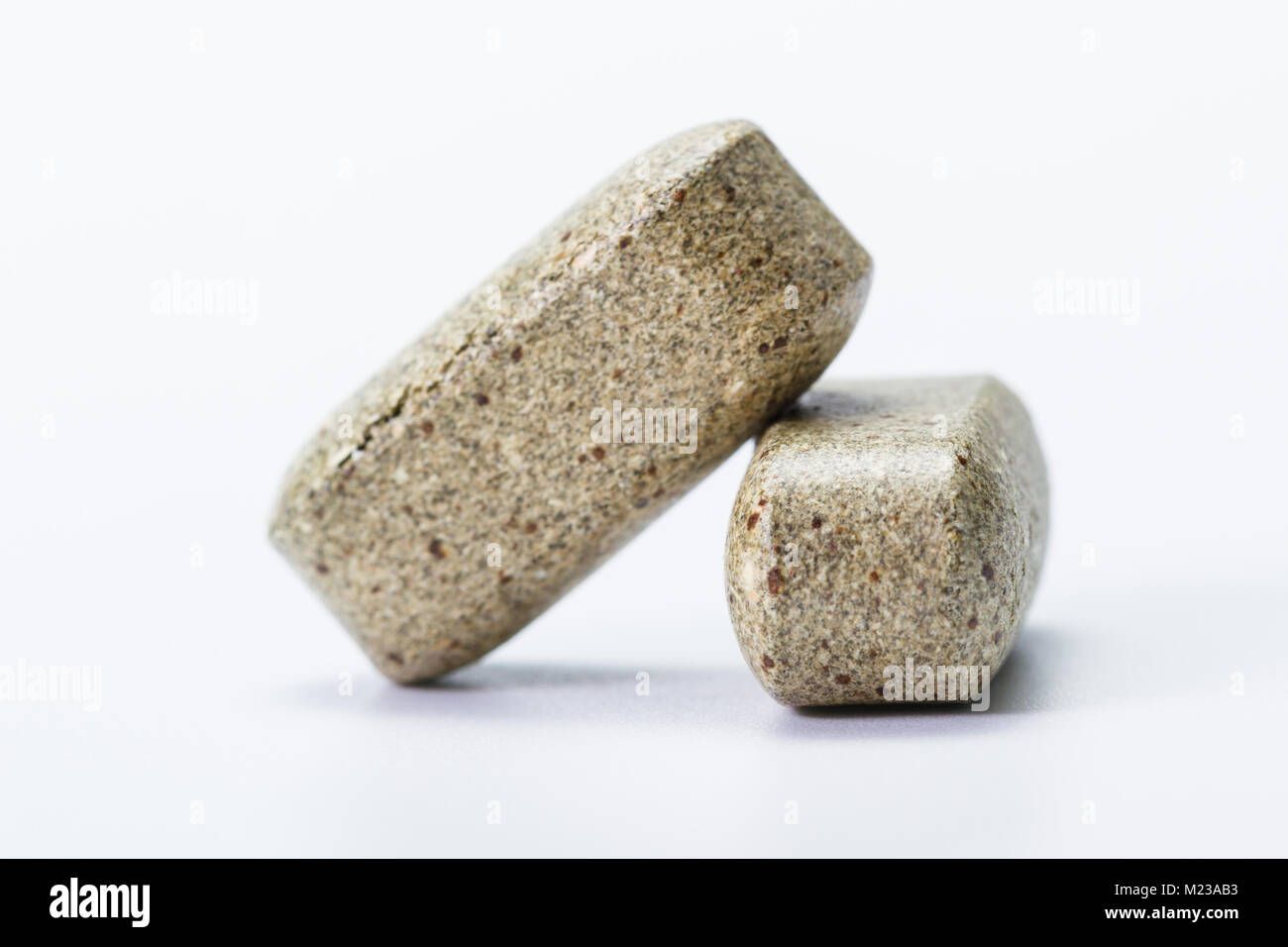 close up of two pretty large heath supplement caplets isolated on a ...