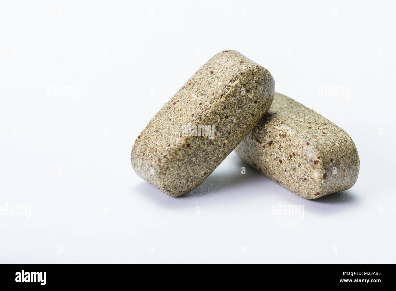 close up of two pretty large heath supplement caplets isolated on a ...