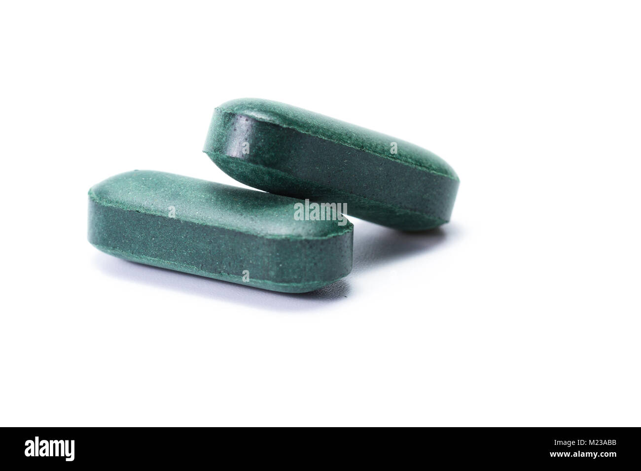 close cup of a serving dose of fermented spirulina tablets isolated on ...