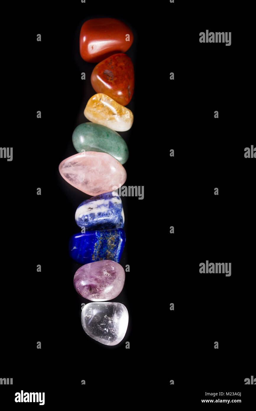 close up of a group of chakra balancing stones isolated on a black ...