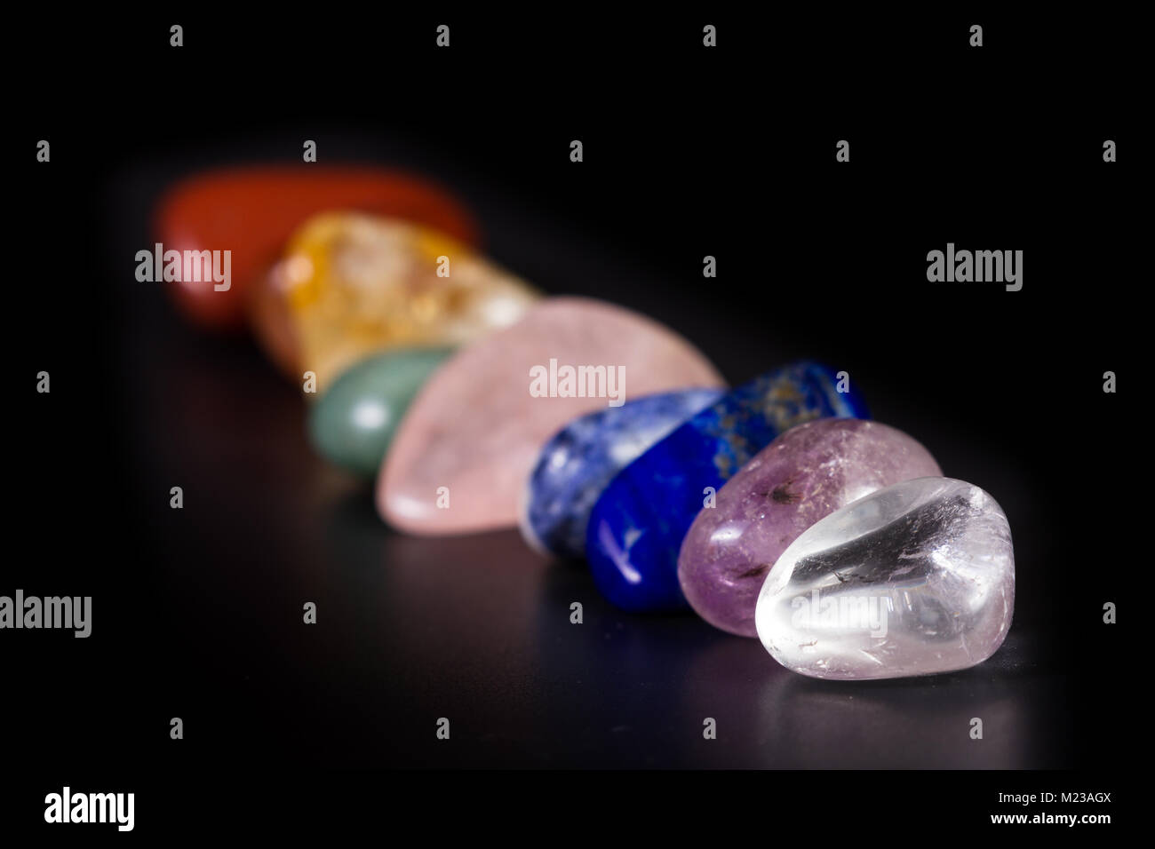 close up of a group of chakra balancing stones isolated on a black ...