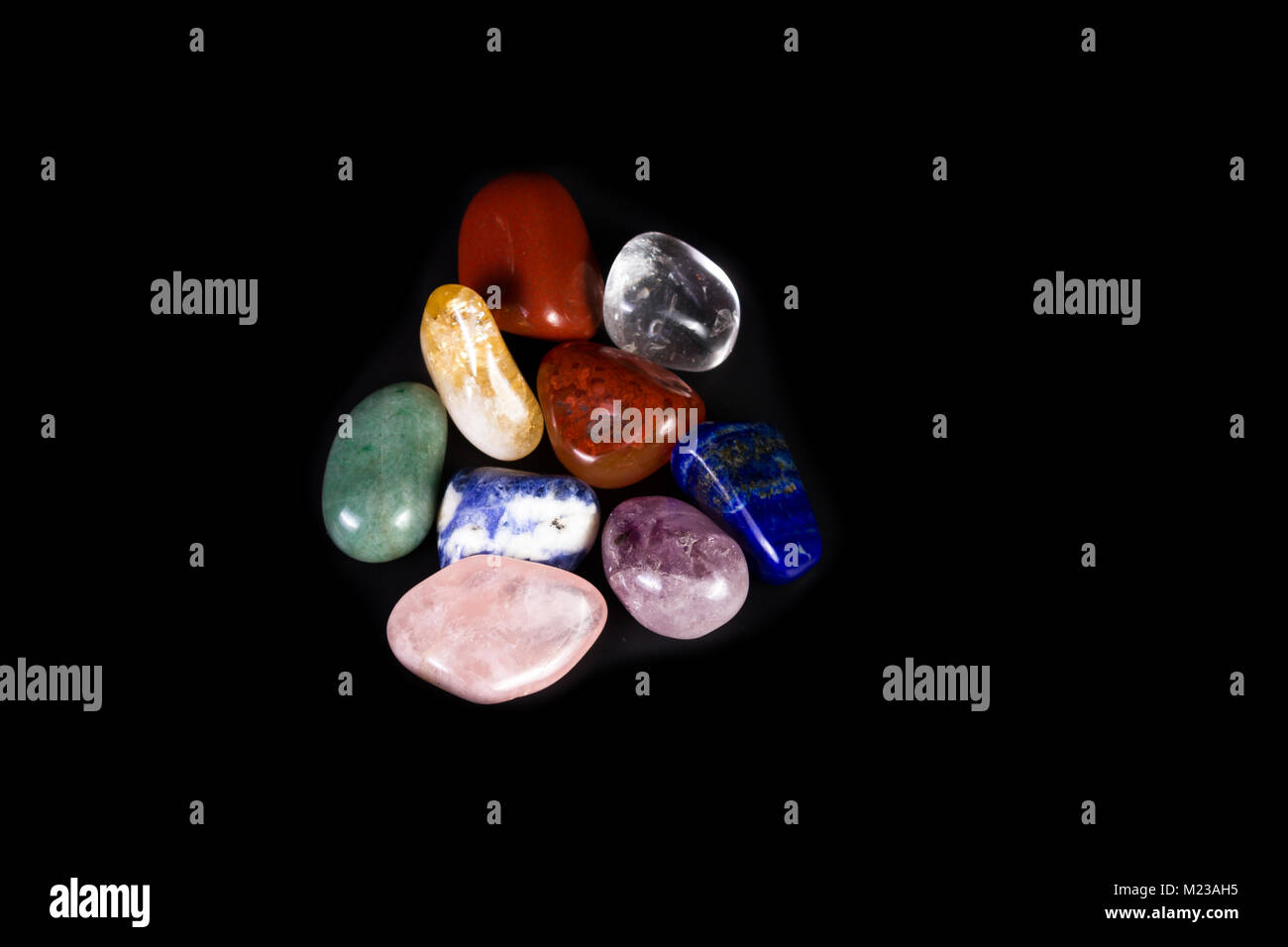 close up of a group of chakra balancing stones isolated on a black ...