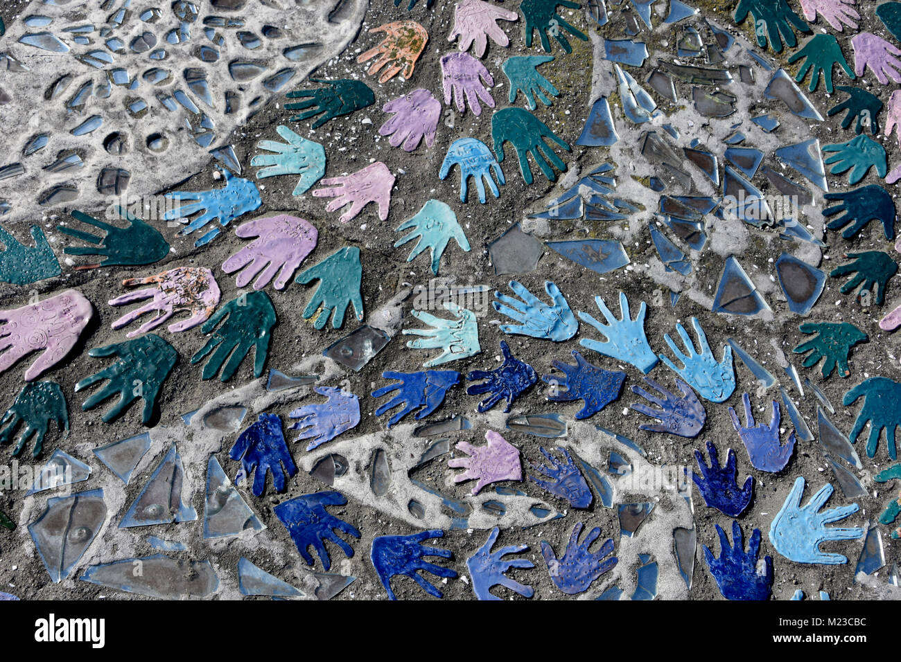 Hand prints in various shades of blue as tiles on an outside path, near ...