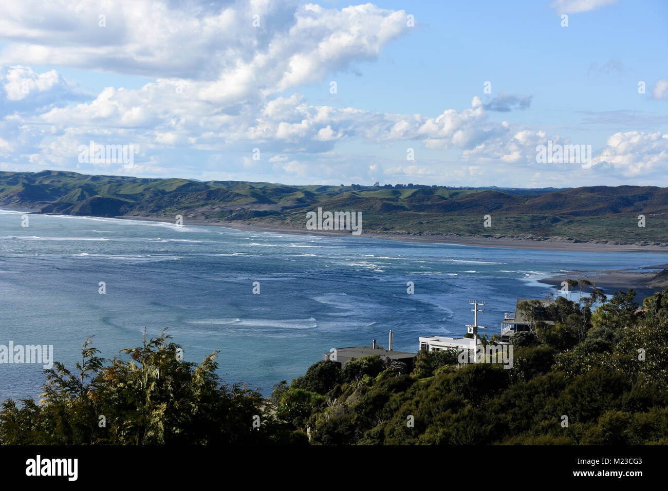 View from the hillside above Raglan surf area with waves and hills in ...