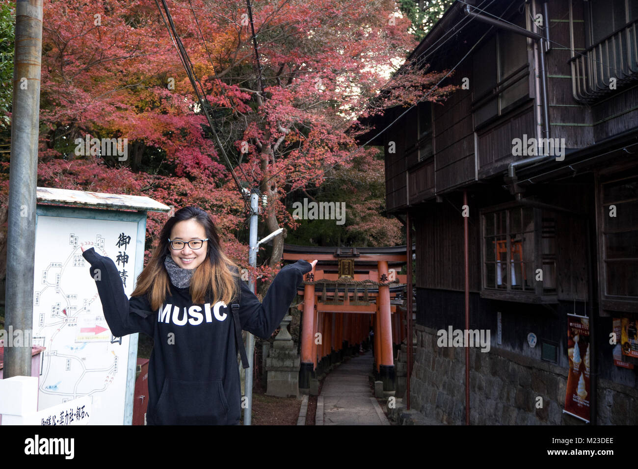 Beautiful female traveller visiting red Torii gates in Fushimi Inari ...