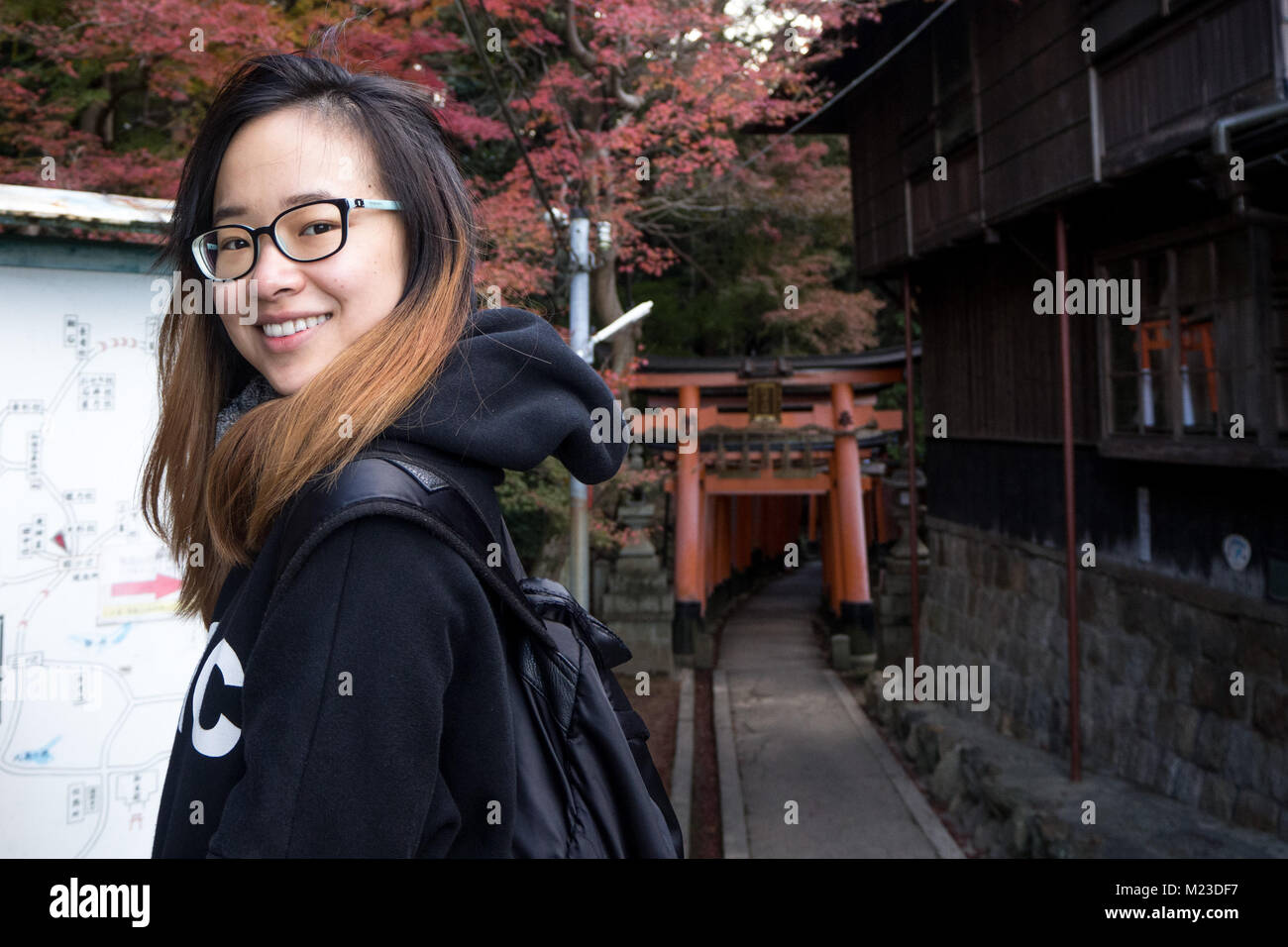 Beautiful female traveller visiting red Torii gates in Fushimi Inari ...