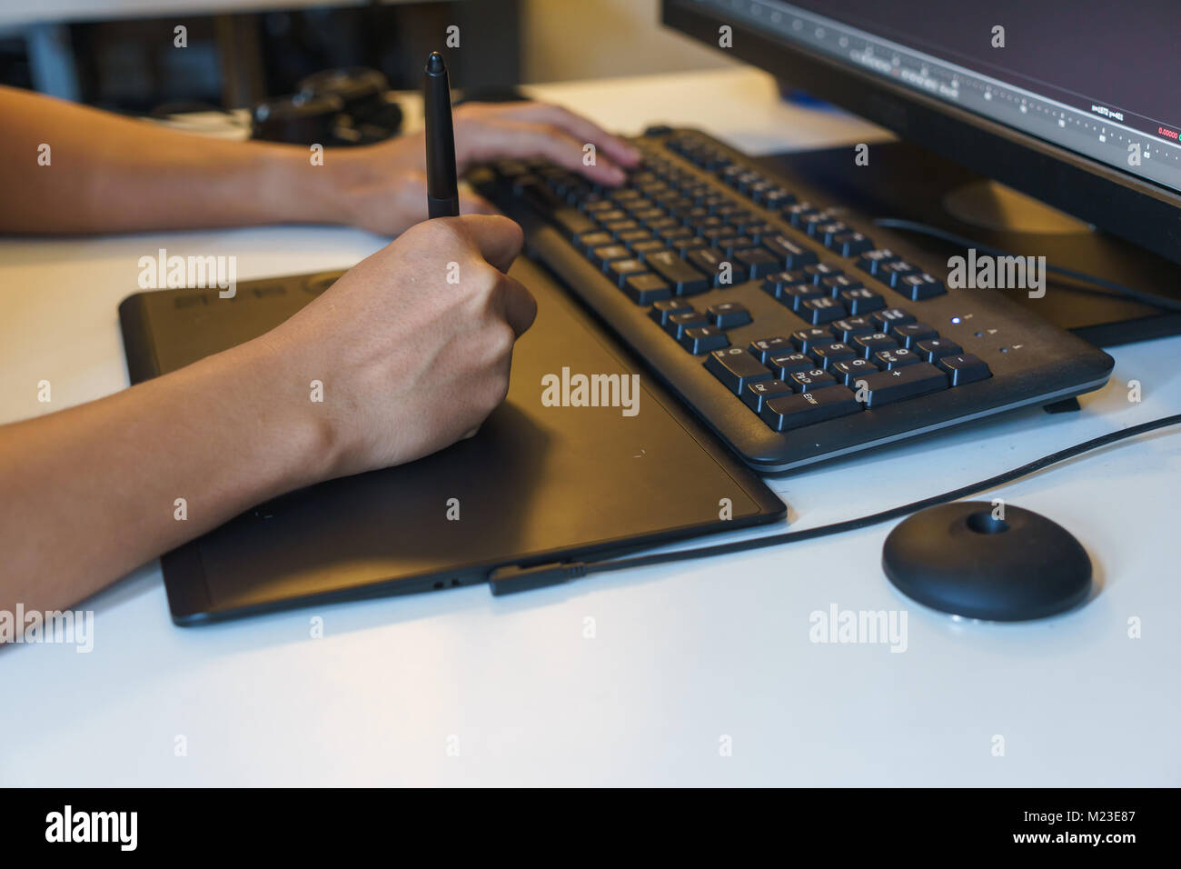 Man Digital Artist working with Drawing tablet in front of computer ...