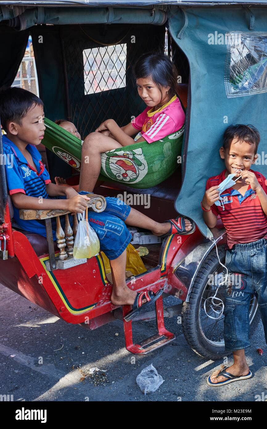 Little girl,boys and baby in hammock inside a tuk-tuk, Phnom Penh ...