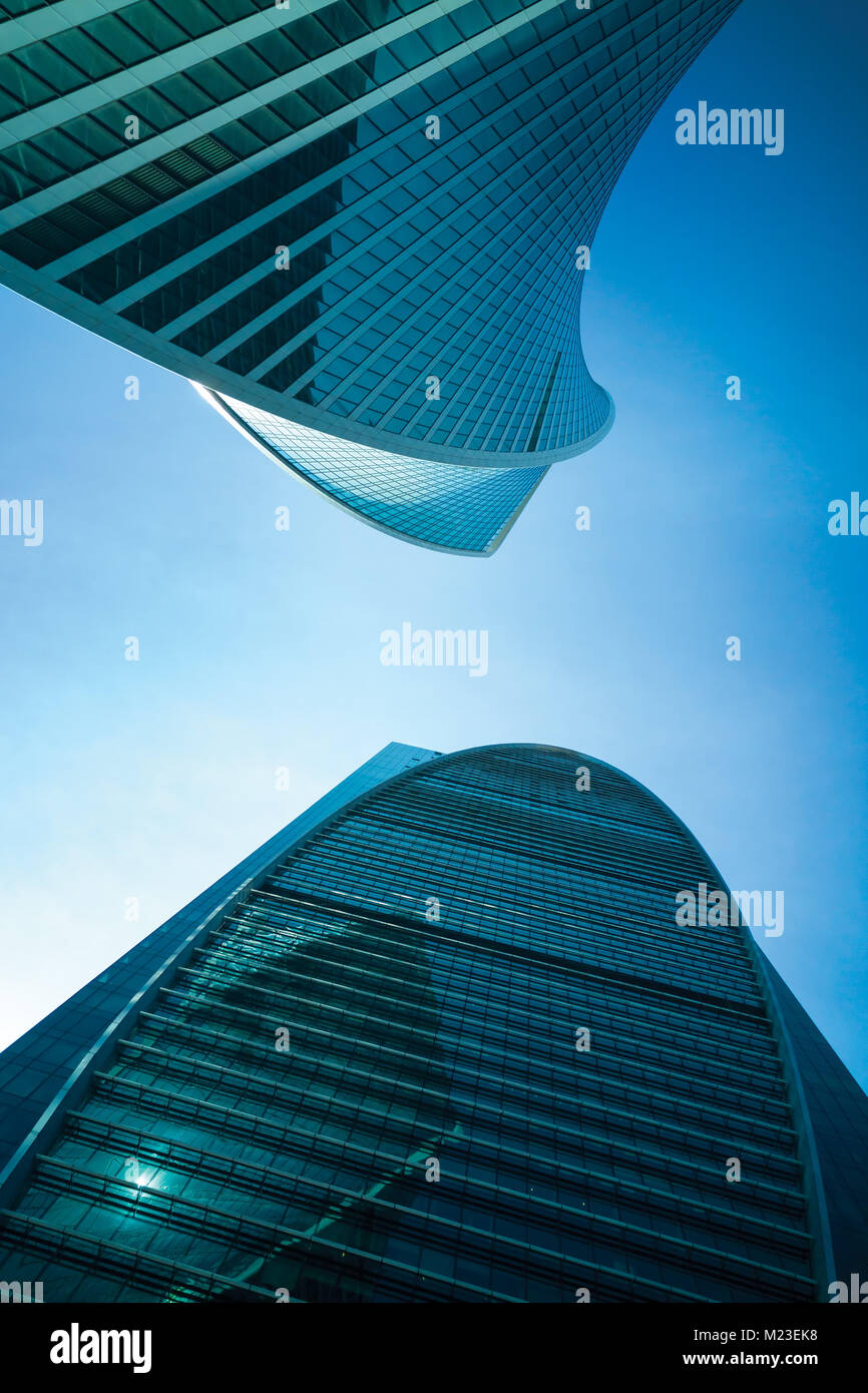 Two skyscraper tops against blue sky perspective view from below Stock ...