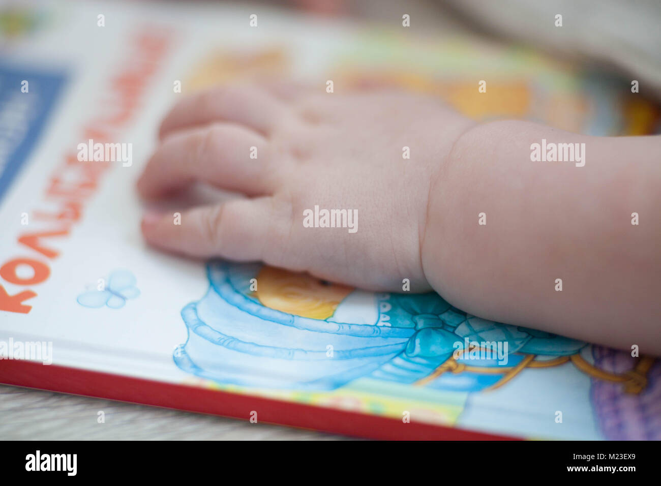 Hand the baby to a children's book. Early development. Close up Stock ...