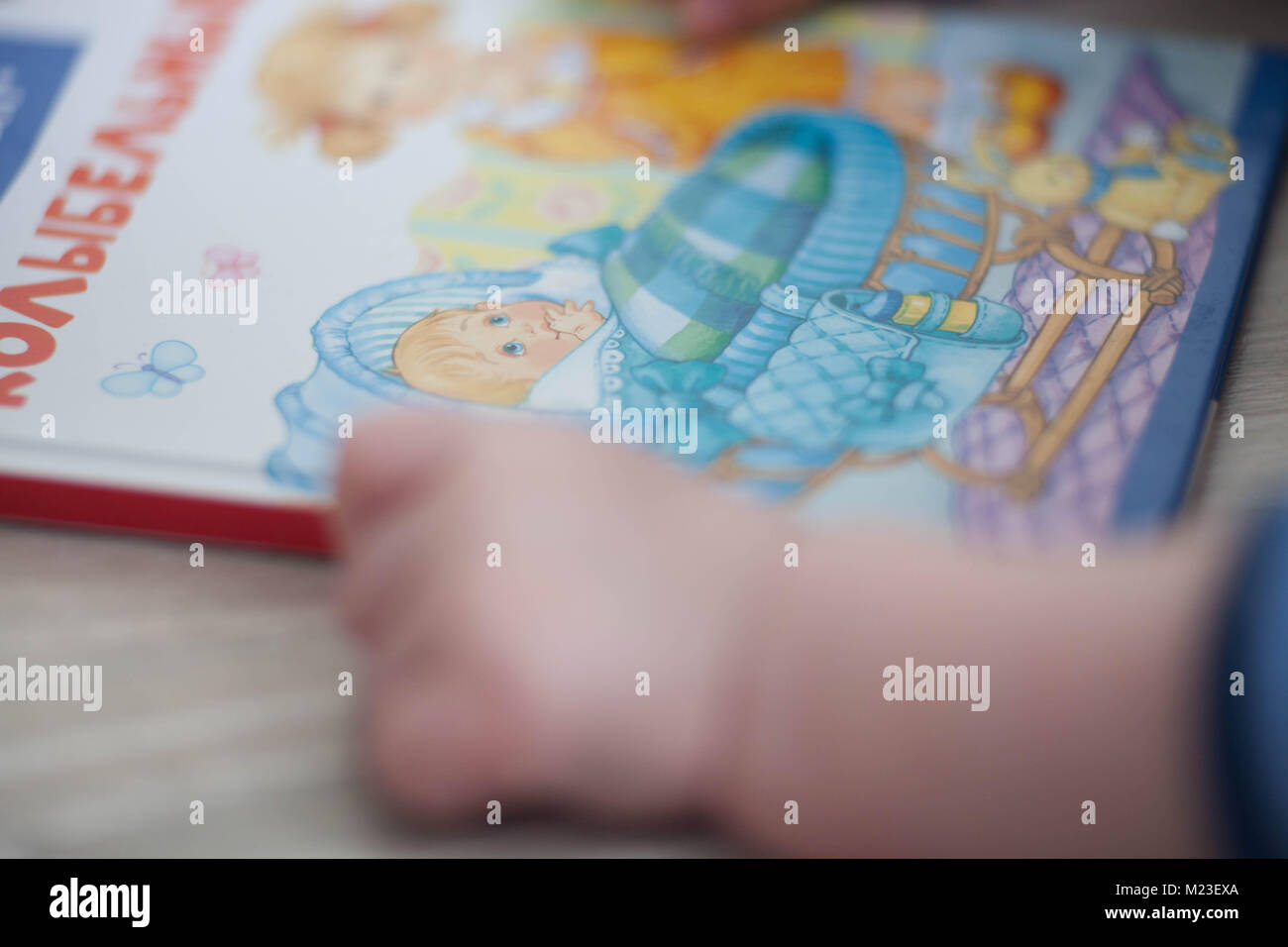 Hand the baby to a children's book. Early development. Close up Stock ...