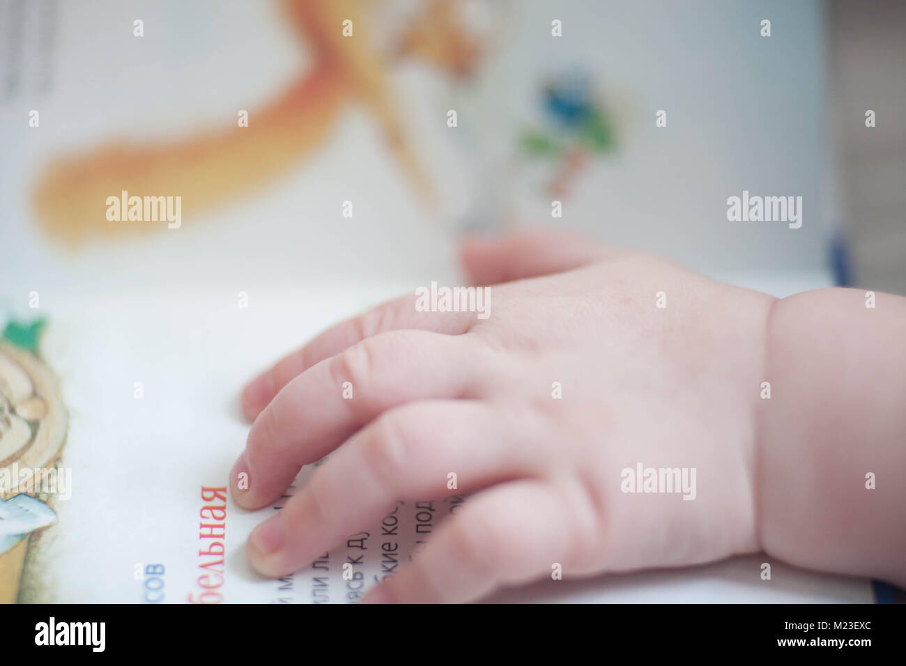 Hand the baby to a children's book. Early development. Close up Stock ...