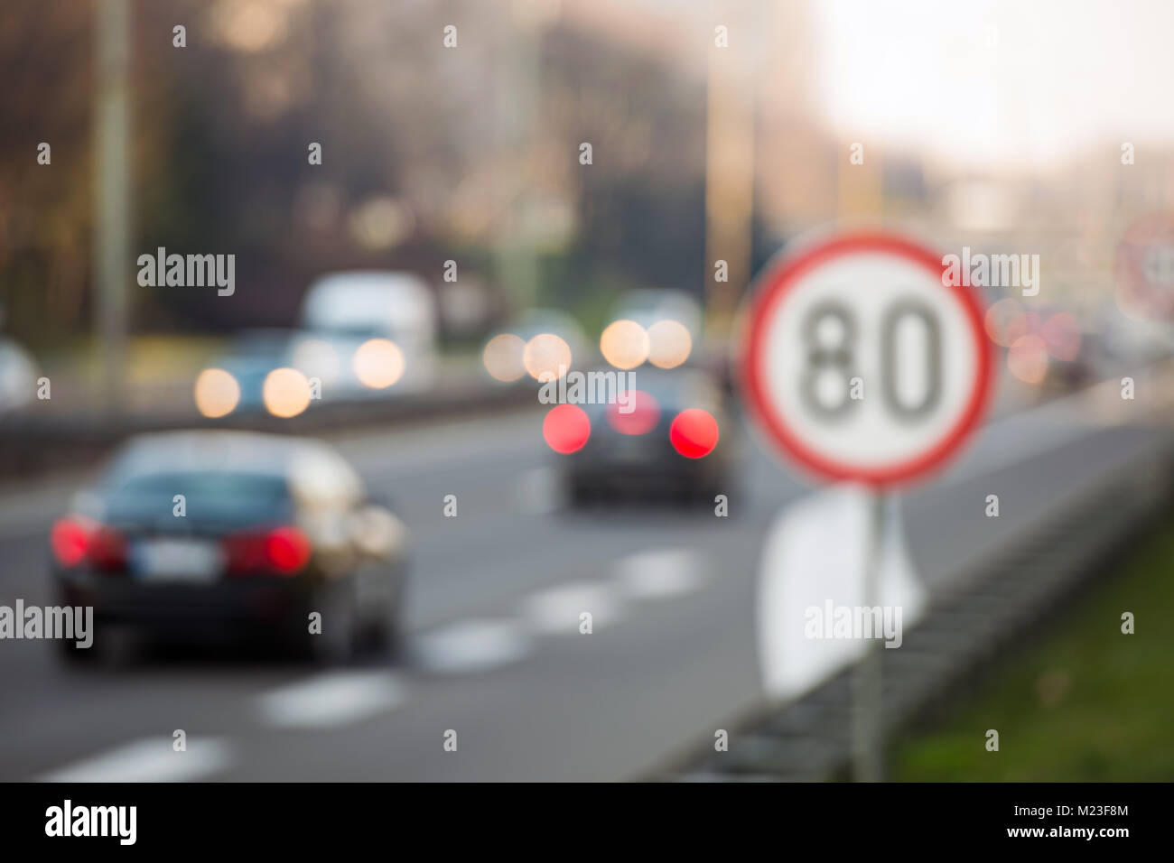 Defocused image of traffic sign showing 80 km/h speed limit on a highway full of cars Stock ...