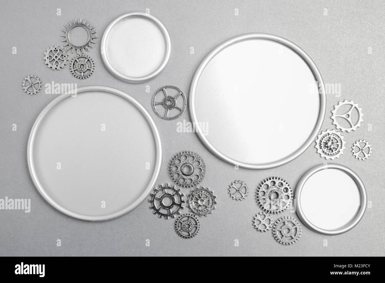 Silver gears and cogs with a round frame with a place for designer's ...