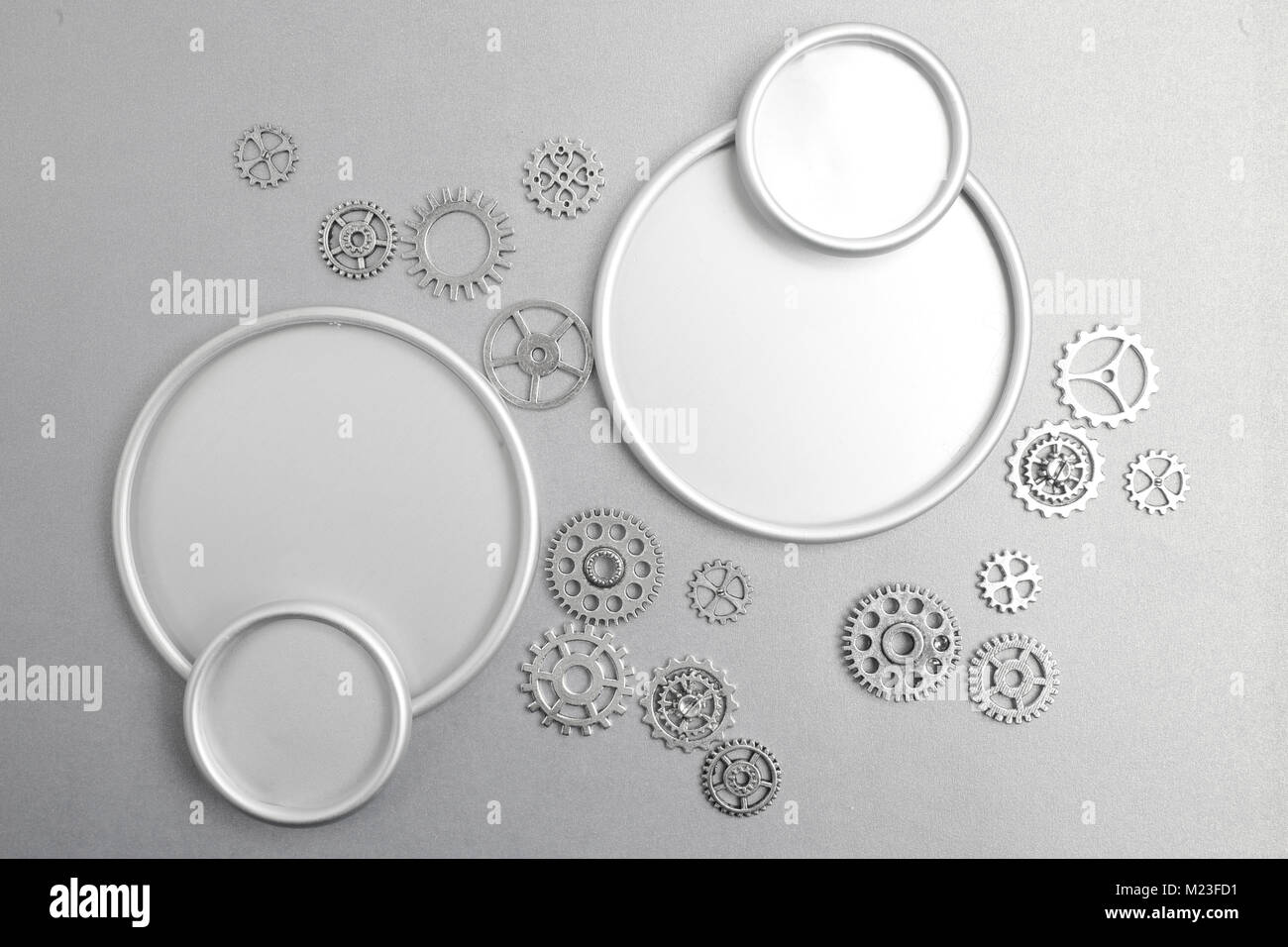 Silver gears and cogs with a round frame with a place for designer's ...