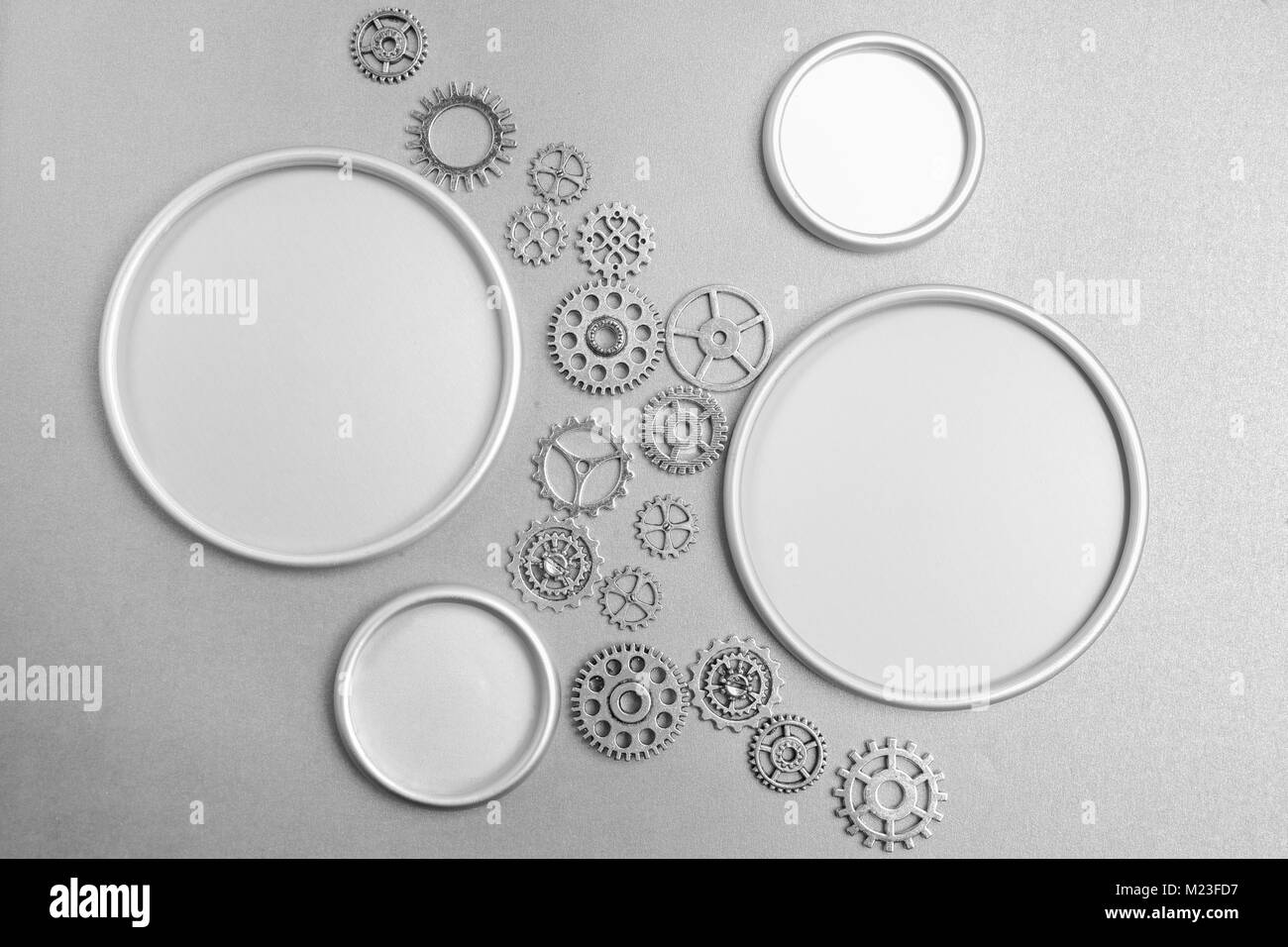 Silver gears and cogs with a round frame with a place for designer's ...