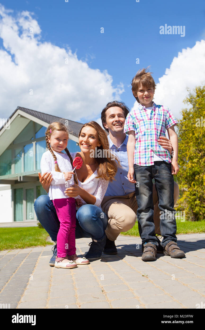 Portrait of happy smiling family and their children near their house ...