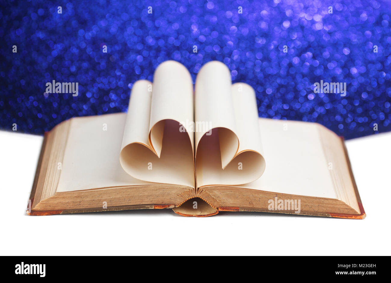 Heart shaped book pages on glitter background Stock Photo - Alamy