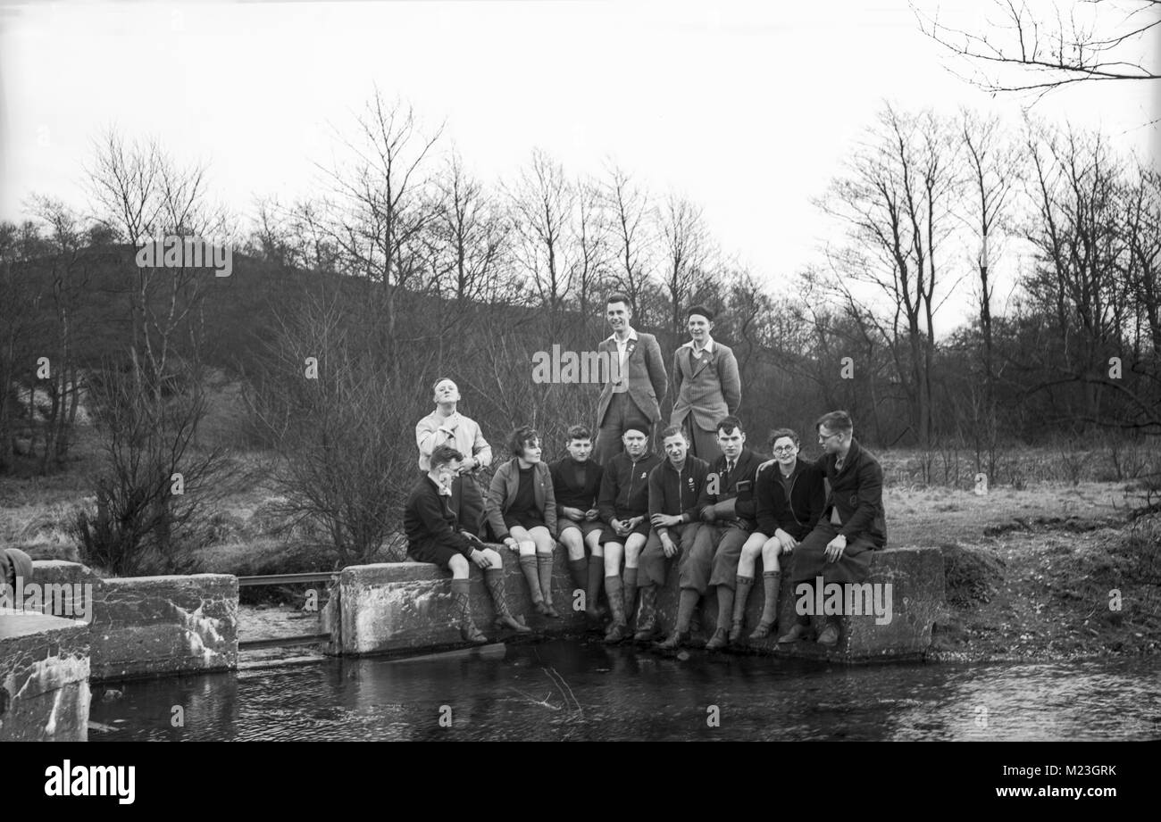 A group of ramblers sitting on a wall at the side of a stream Stock ...