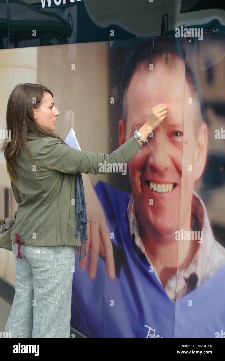 Young female artist working on street art, hoarding Stock Photo - Alamy