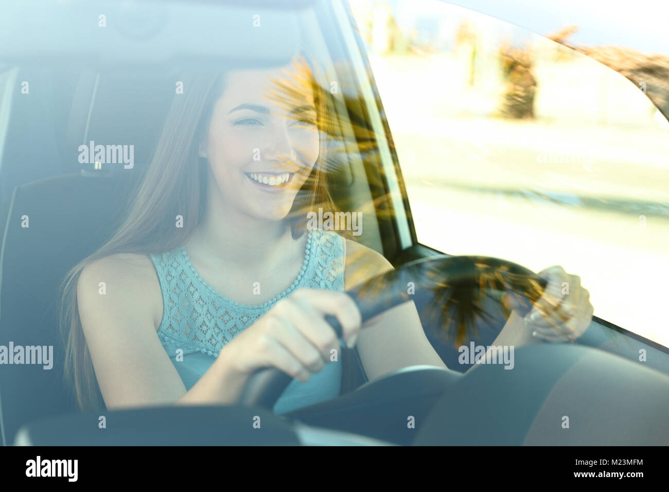 Portrait of a happy attentive driver woman driving a car on the road ...