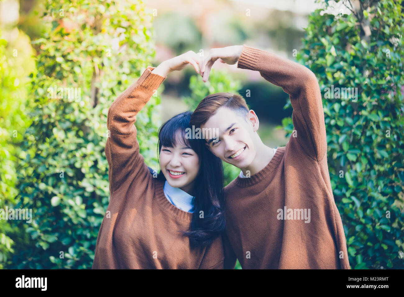 Beautiful young couple making heart shape with hands and Smiling happy ...